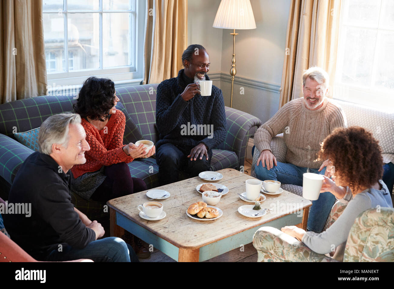 Group Of Middle Aged Friends Meeting Around Table In Coffee Shop Stock ...