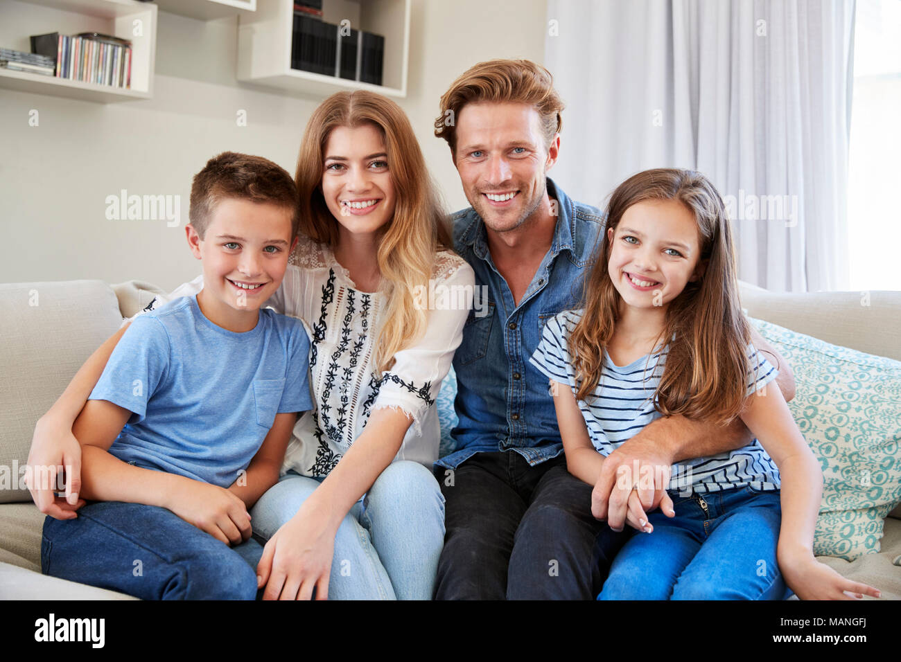 Portrait Of Smiling Family Sitting On Sofa At Home Together Stock Photo ...