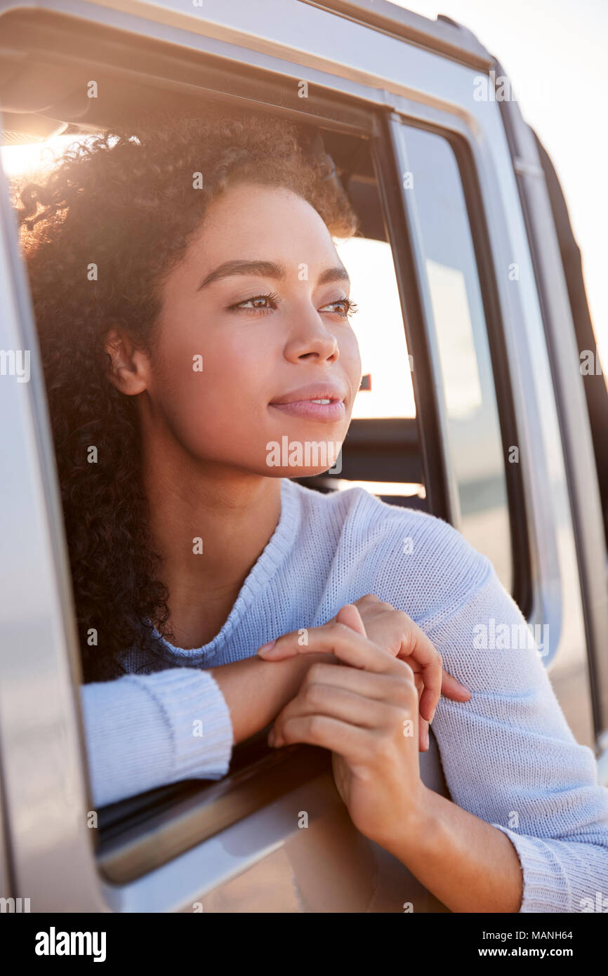 Woman looking out of front passenger car window, vertical Stock Photo ...
