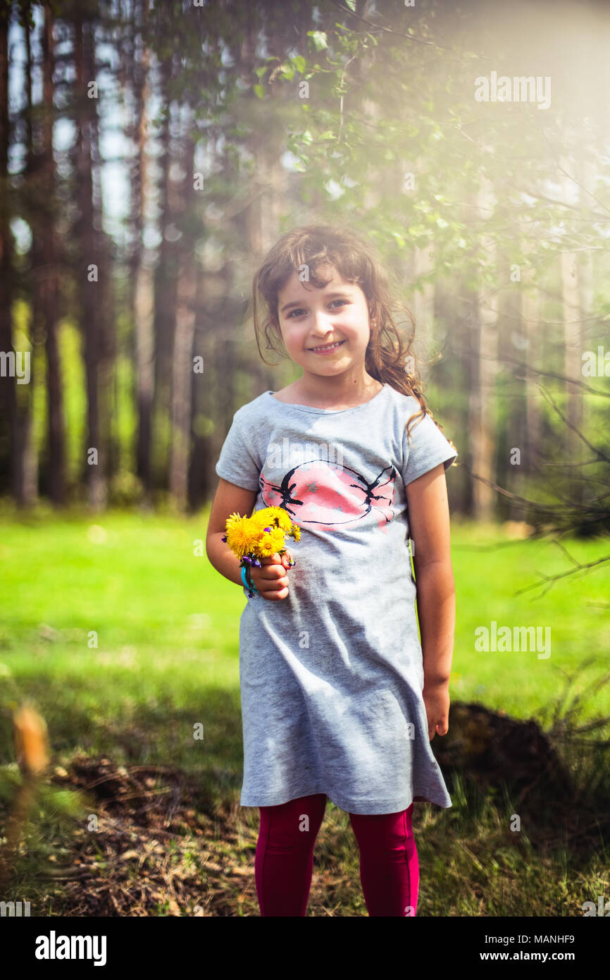 Pretty little girl in the mountain forest, spring landscape background ...