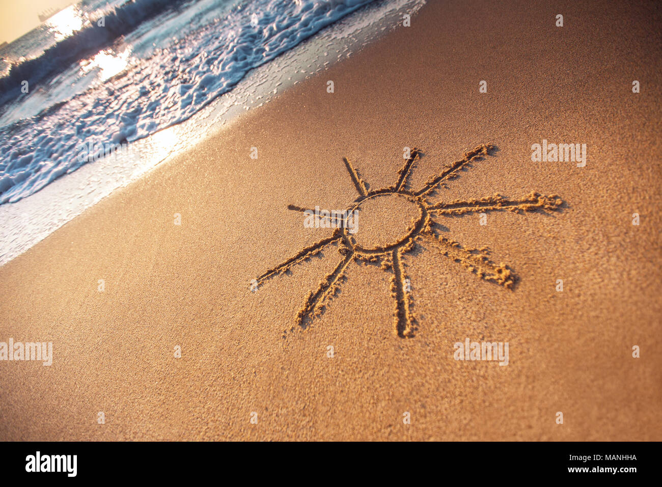 Simple sun drawing in the sand on the beach Stock Photo - Alamy