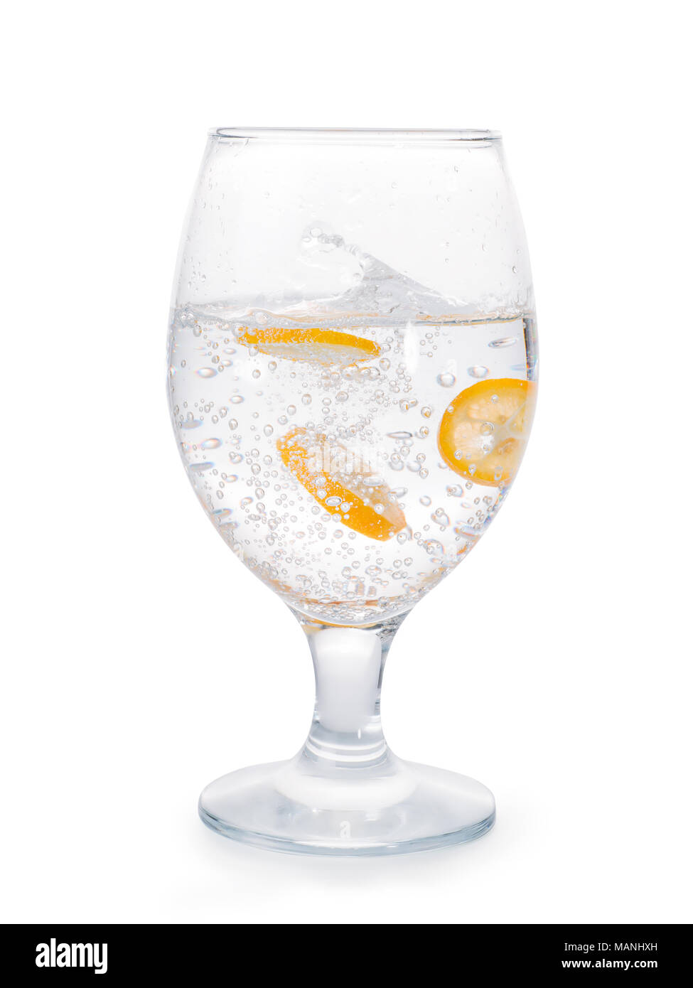 Glass of clear carbonated drink with falling orange citrus fruit slices, bubbles and splash ...