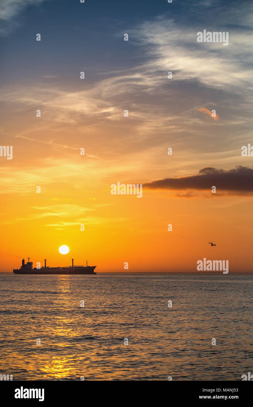 Calm sea silhouette of fishing boat and setting sun hi-res stock ...