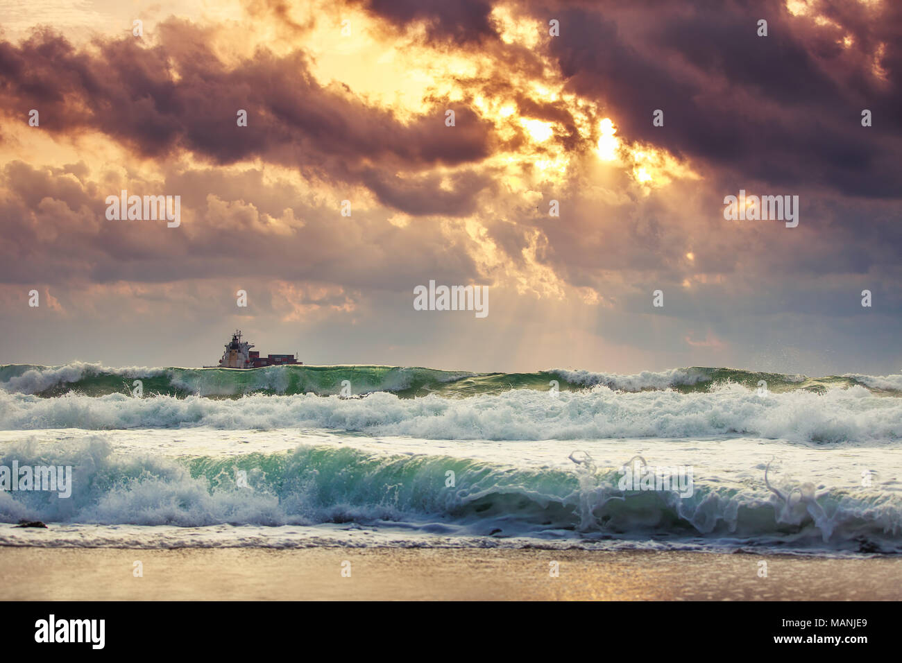 Sun setting at the sea with sailing cargo ship, scenic view Stock Photo ...