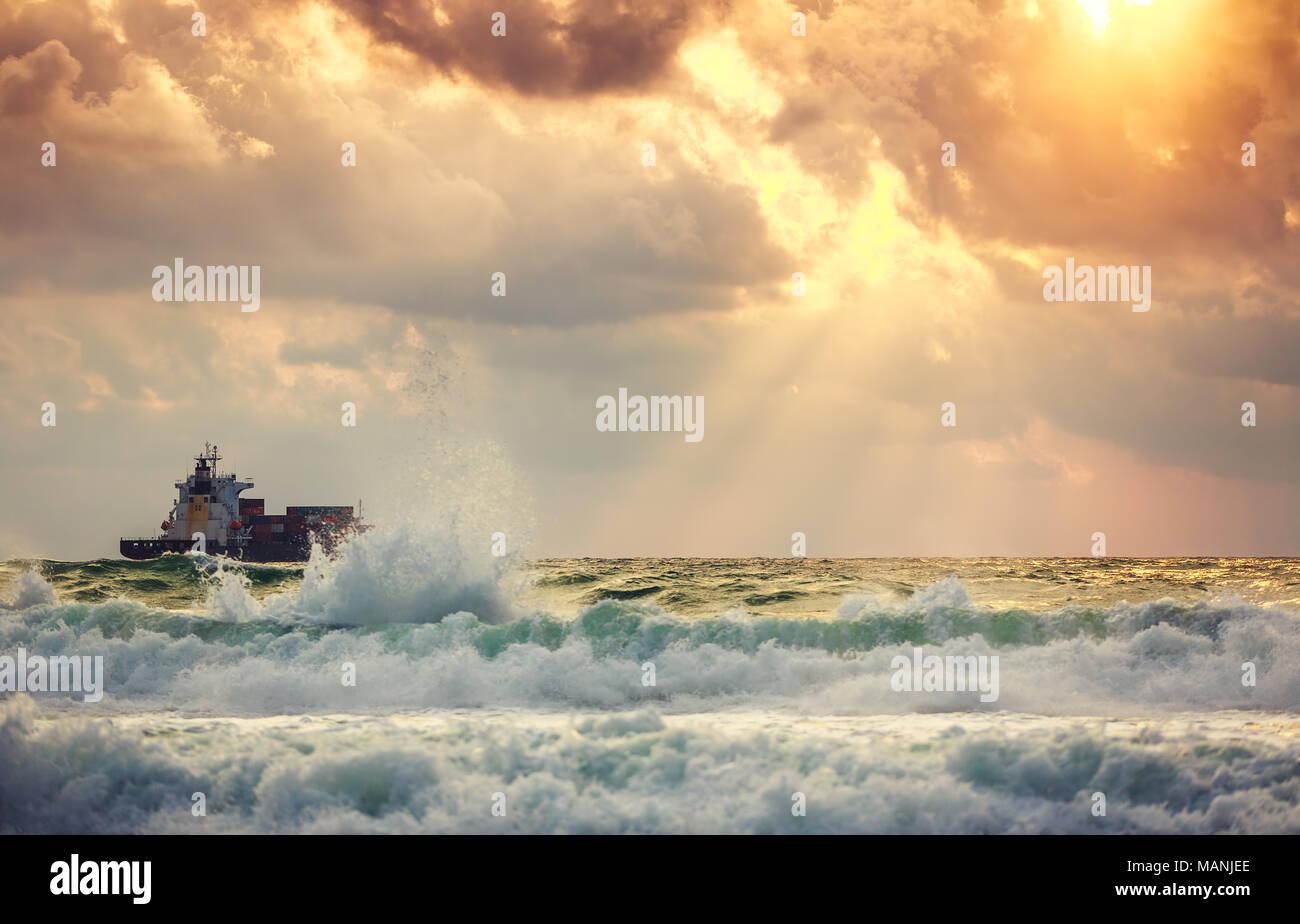 Sun setting at the sea with sailing cargo ship, scenic view Stock Photo ...