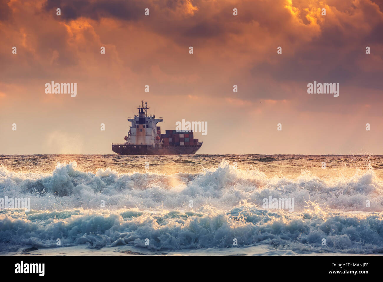 Sun setting at the sea with sailing cargo ship, scenic view Stock Photo ...