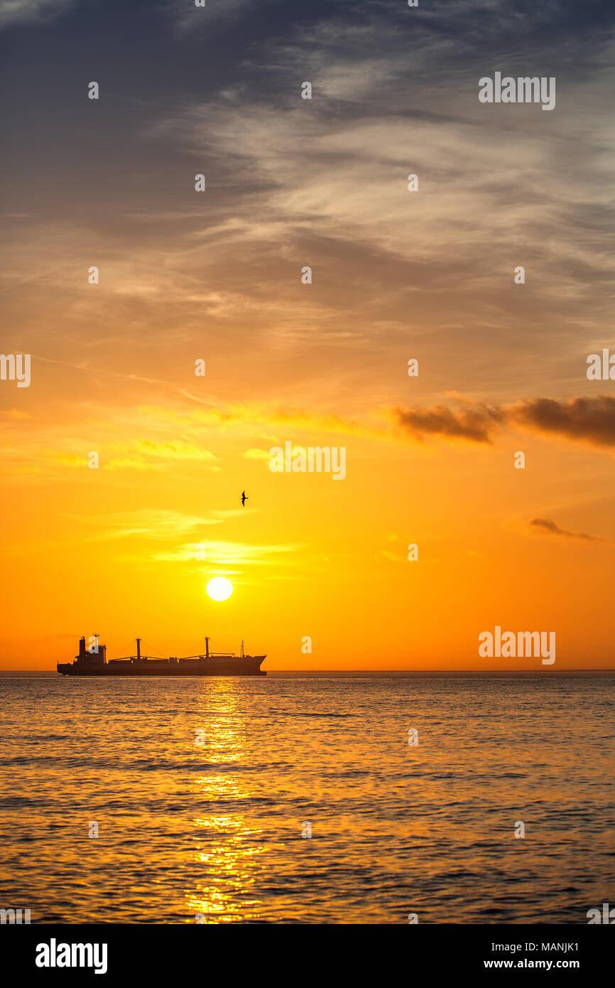 Calm sea silhouette of fishing boat and setting sun hi-res stock ...