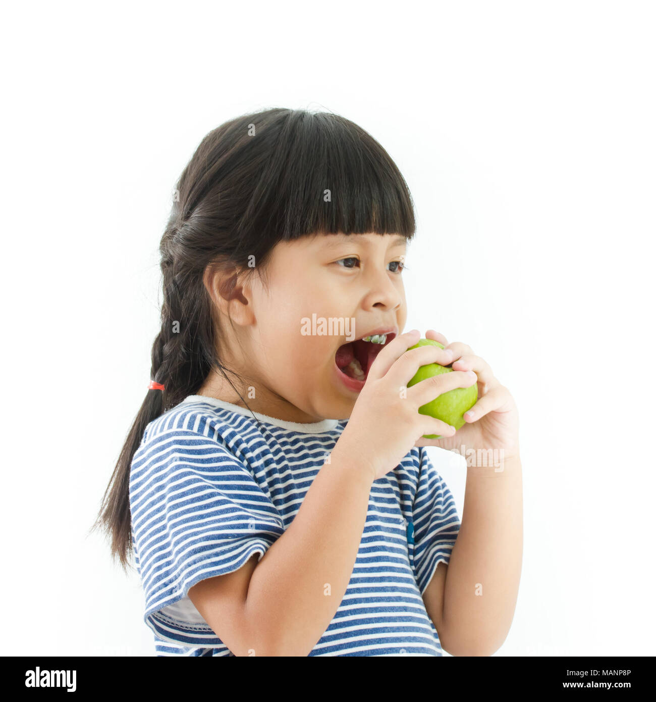 little girl eating green apple on white background Stock Photo - Alamy