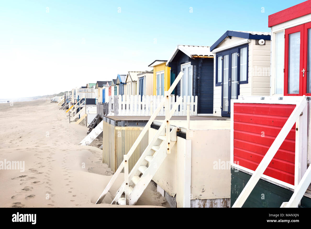 Beautiful painted beach huts or small houses onto a beach. Beach dunes ...
