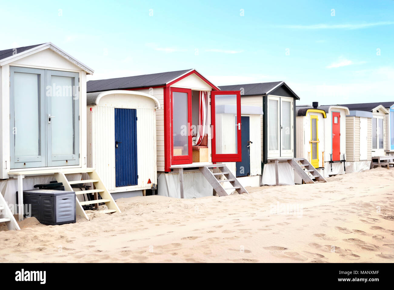 Beautiful painted beach huts or small houses onto a beach. Beach dunes ...
