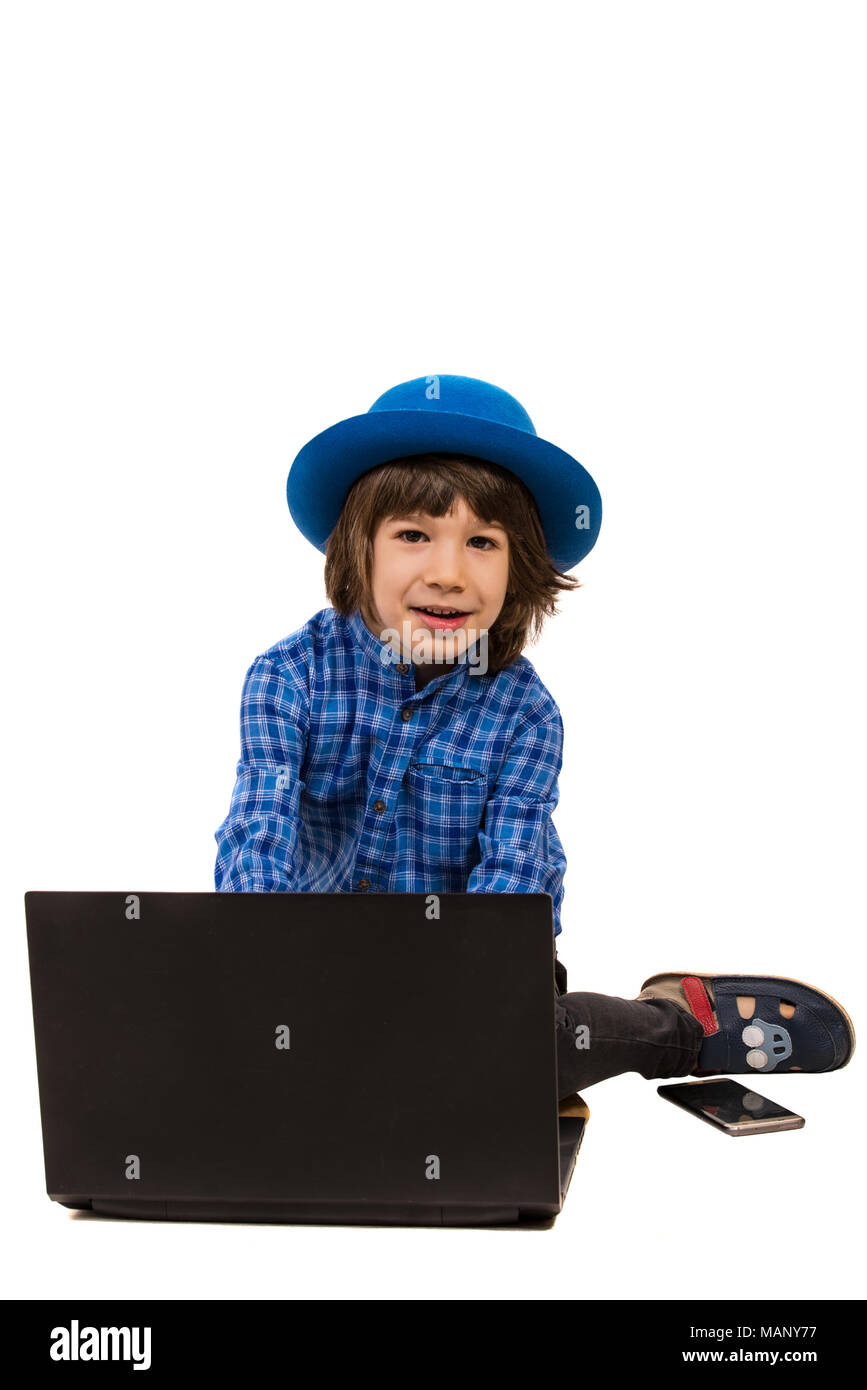 Cute little executive child boy typing on laptop and sitting down ...