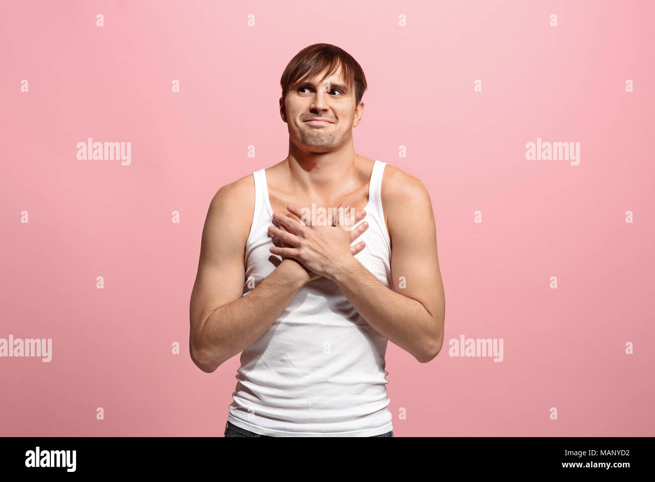 The happy man standing and smiling against pink background Stock Photo ...