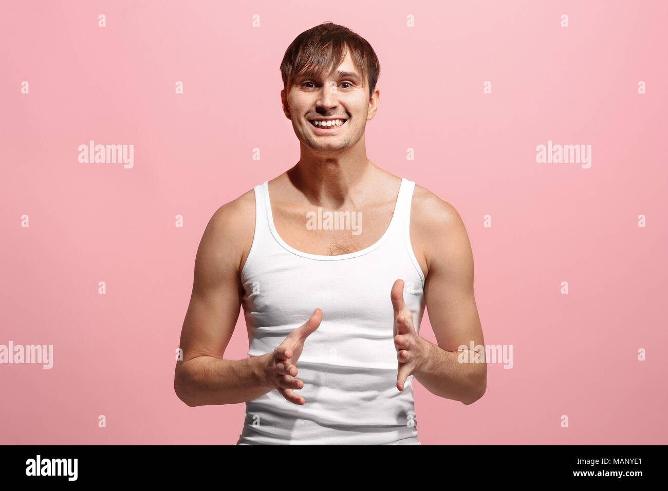 The happy man standing and smiling against pink background Stock Photo ...