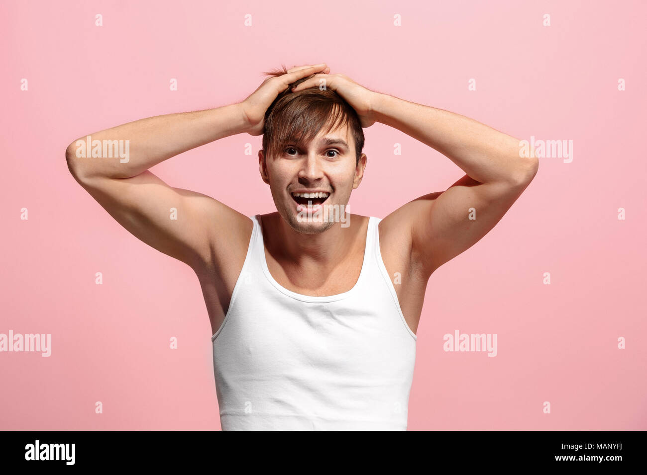 The happy man standing and smiling against pink background Stock Photo ...