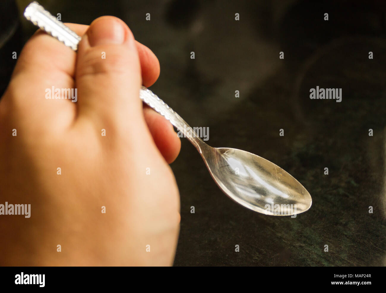 Hand holding a spoon Stock Photo - Alamy