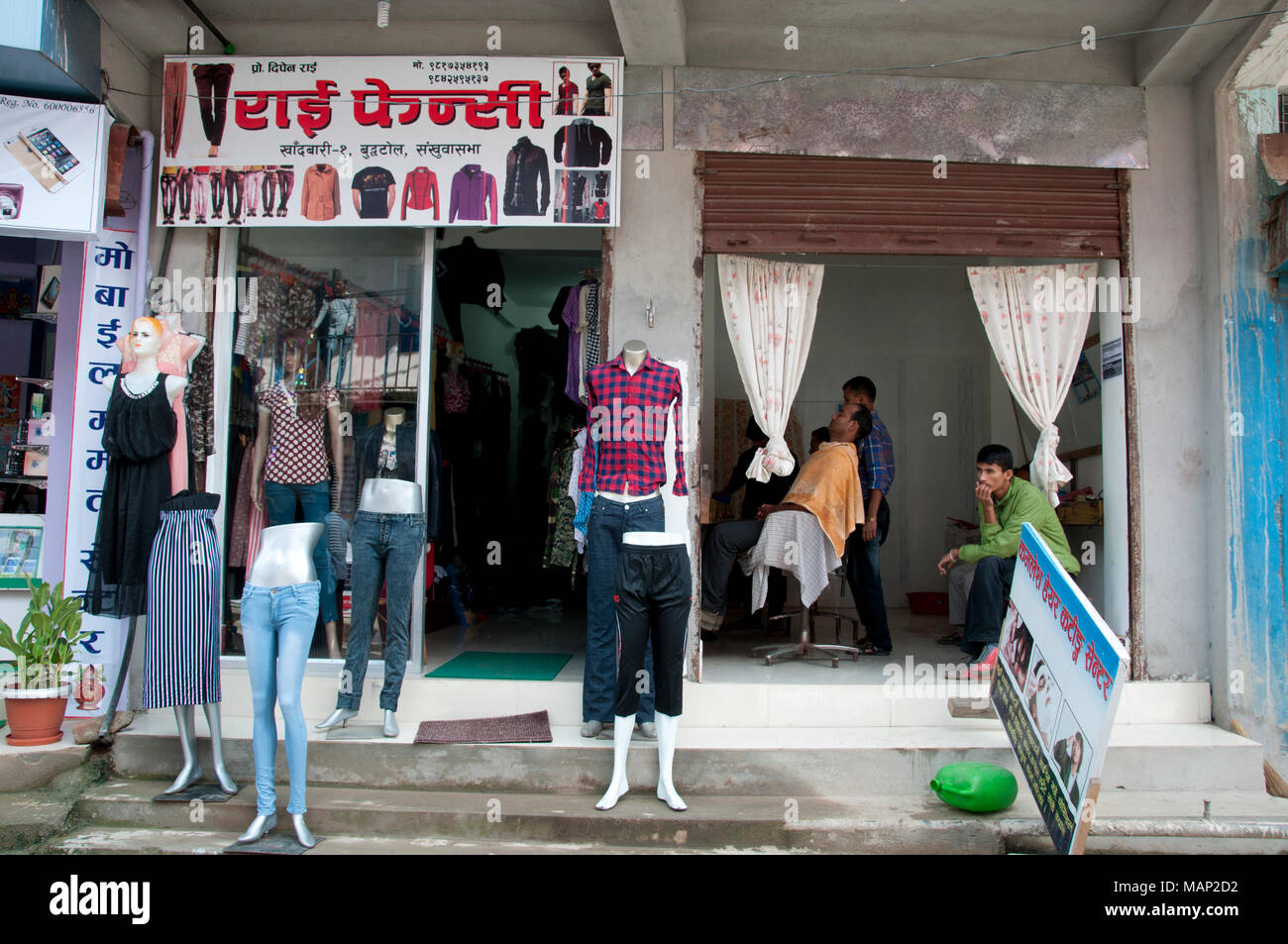 Nepal 2014. Khandbari. Clothes shop and hairdressers Stock Photo - Alamy