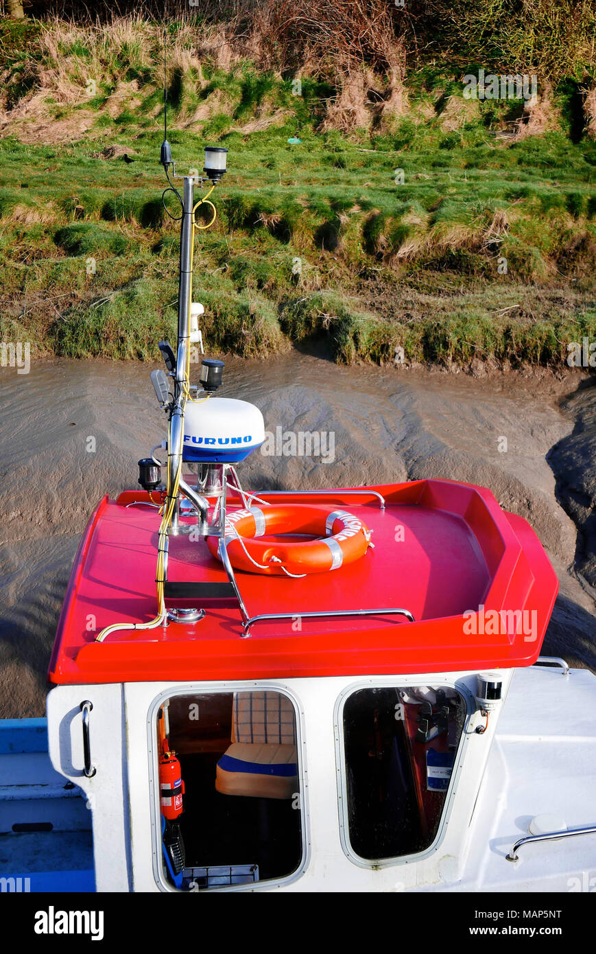Red roof of small boat against mud bank and marsh grass Stock Photo - Alamy