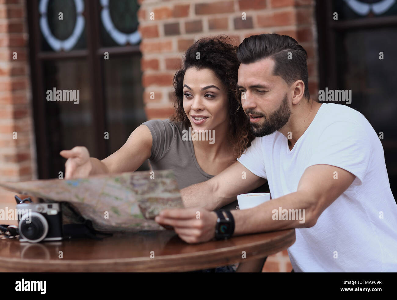 Young tourists having coffee at cafe and reading map Stock Photo - Alamy