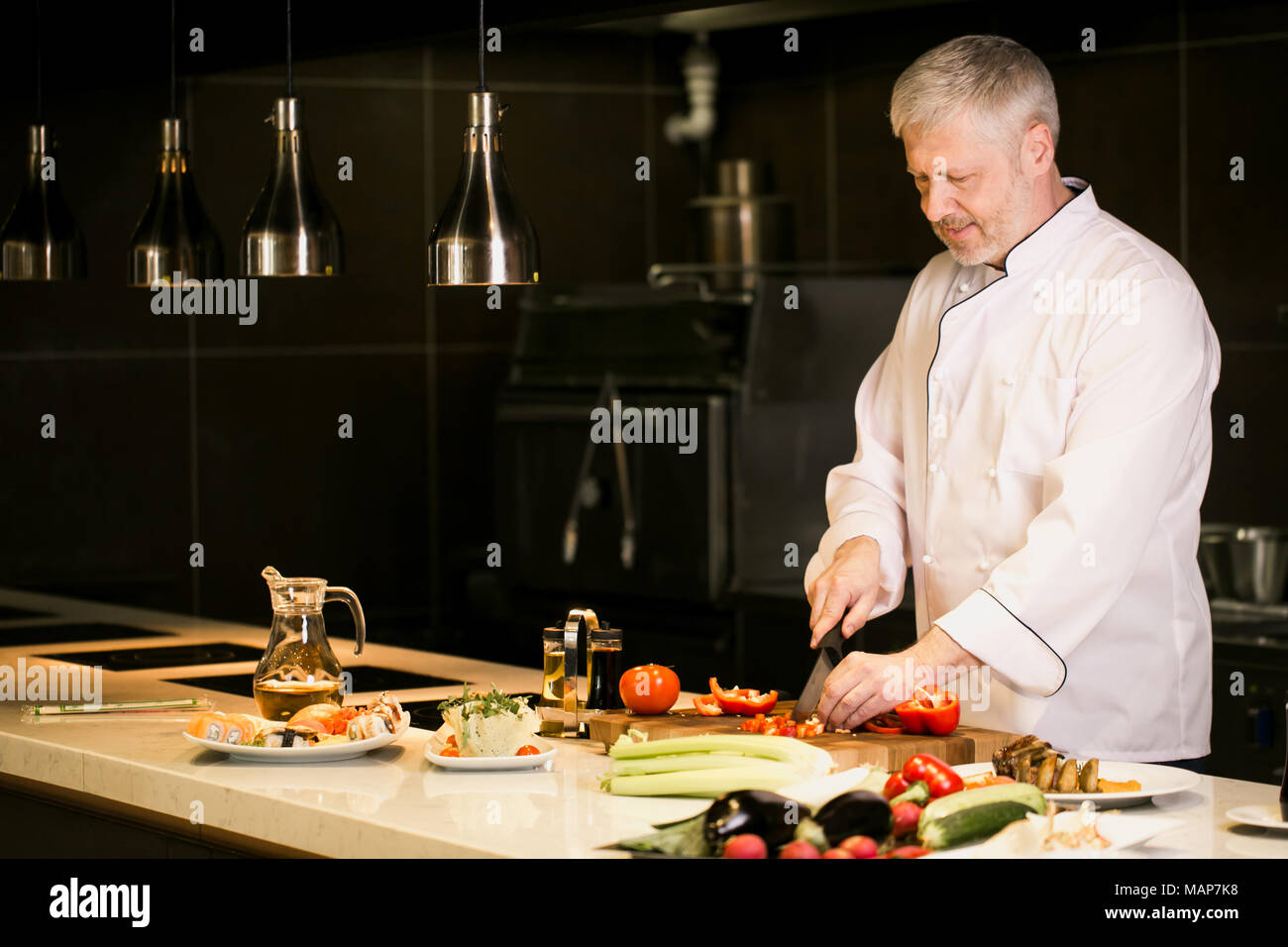 side view shot of good-looking grown up making a chef salad at the ...