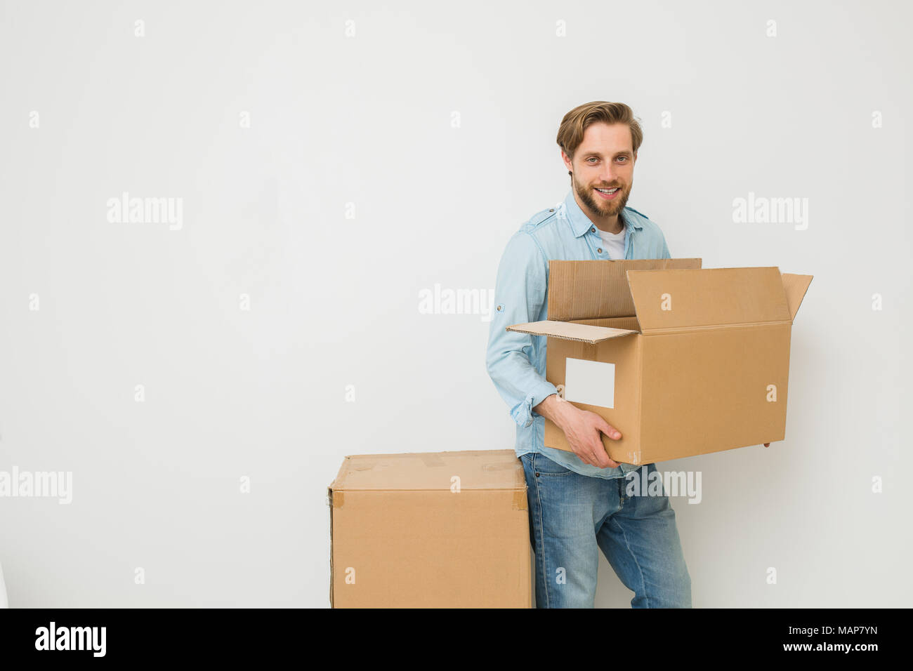 a young blonde man, carrying some cardboard boxes, delivery man, or a ...