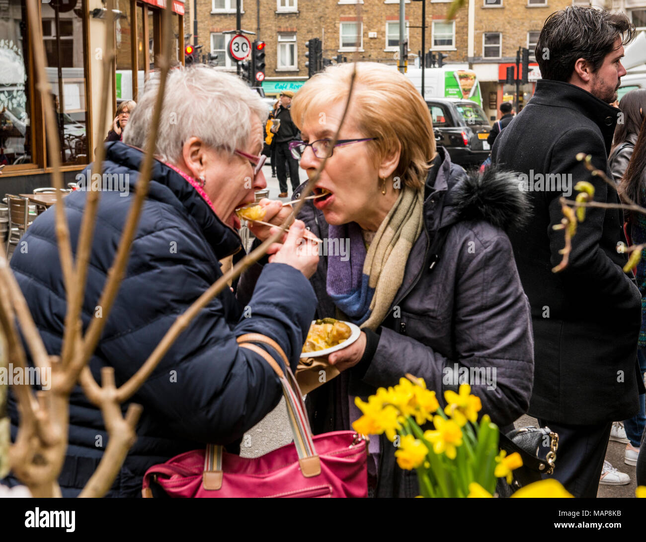 Two women eating street food near Borough Market, Southwark, London ...