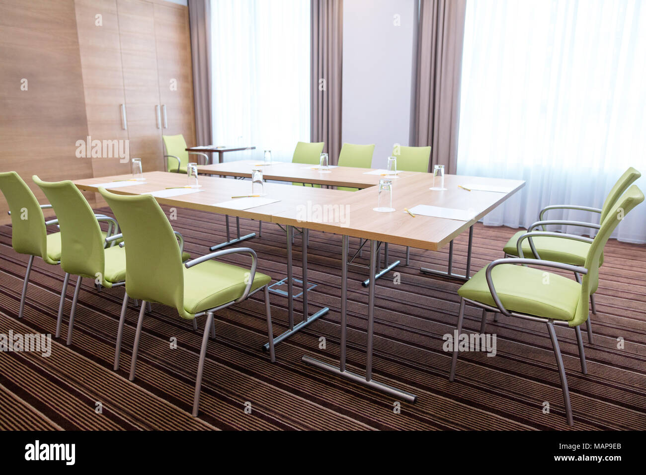 interior of light committee room furnished with modern table and green ...