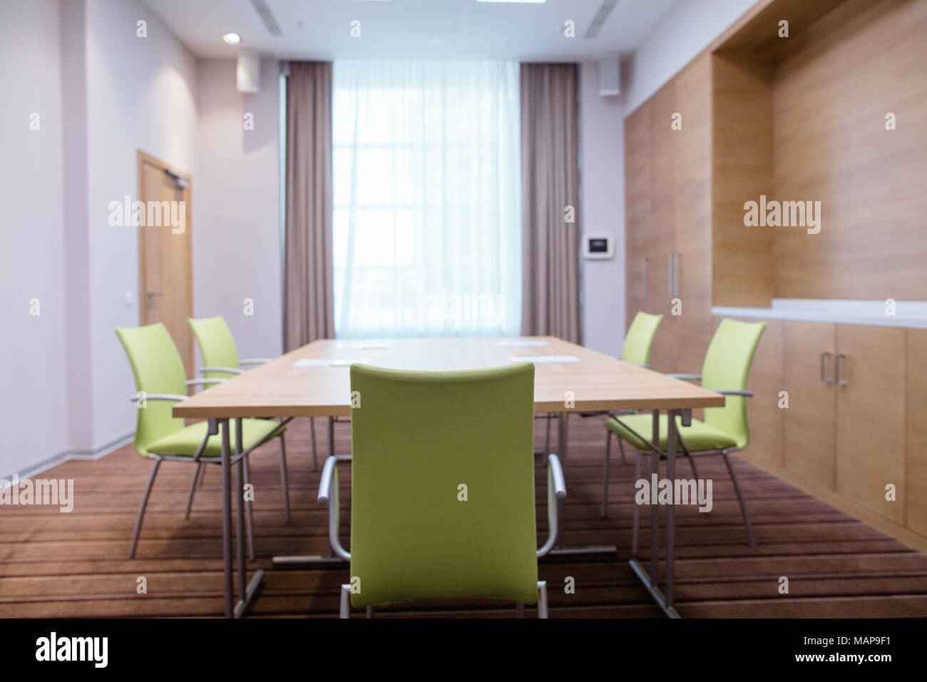 light meeting room with custom-build furniture, brown curtains and ...