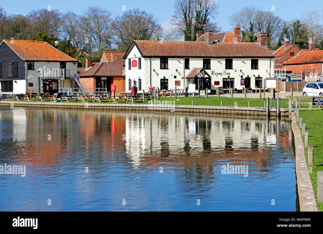 A view of the Rising Sun public house with reflection by the River Bure ...