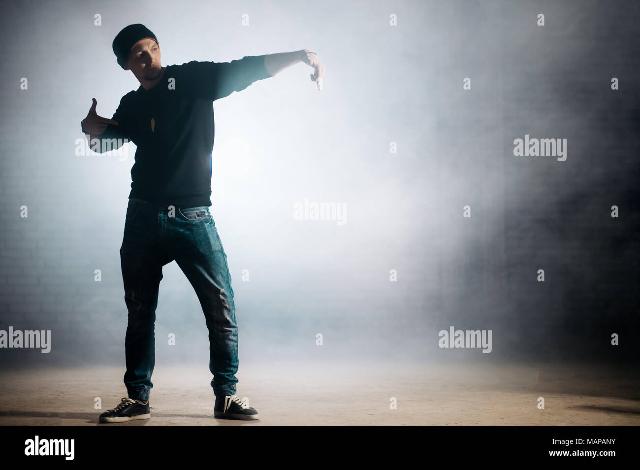rapper wearing jeans,sweater demonstrating gesture Stock Photo - Alamy