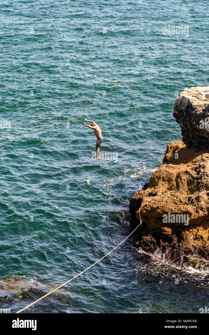 Man jumping from the cliff into the sea Stock Photo - Alamy