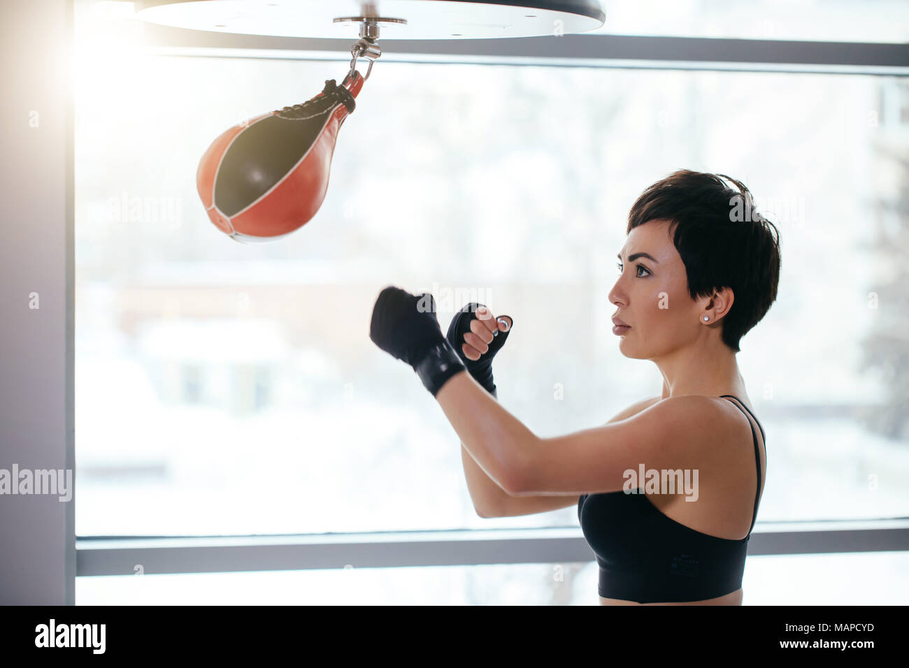side view shot of martial arts fighter striking small boxing pear Stock ...