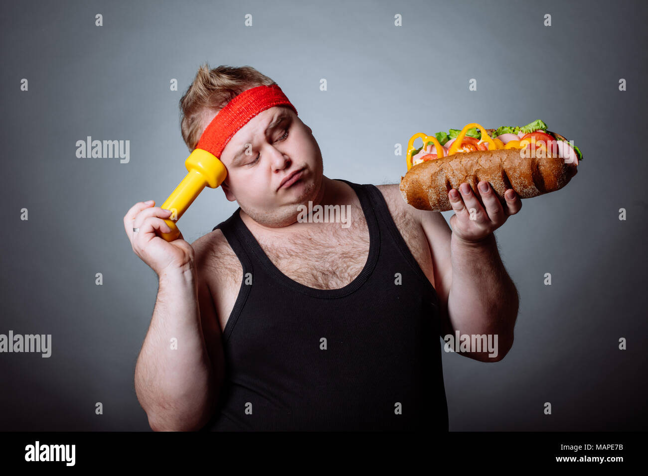 fat man looking at camera and holding burger and dumbbell Stock Photo ...