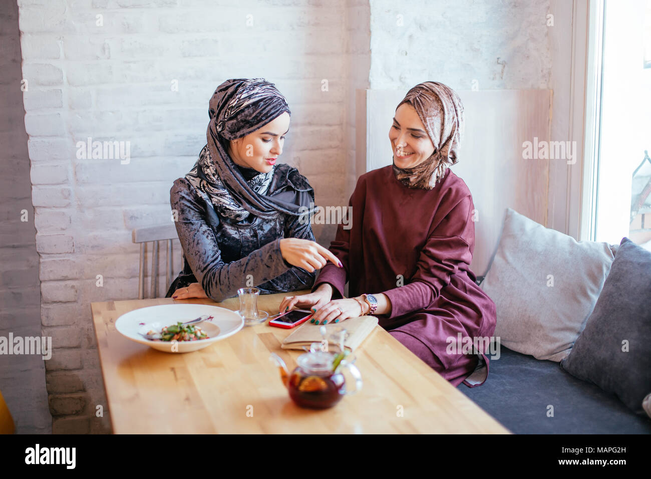 Two Muslim women in cafe, friends meeting Stock Photo - Alamy