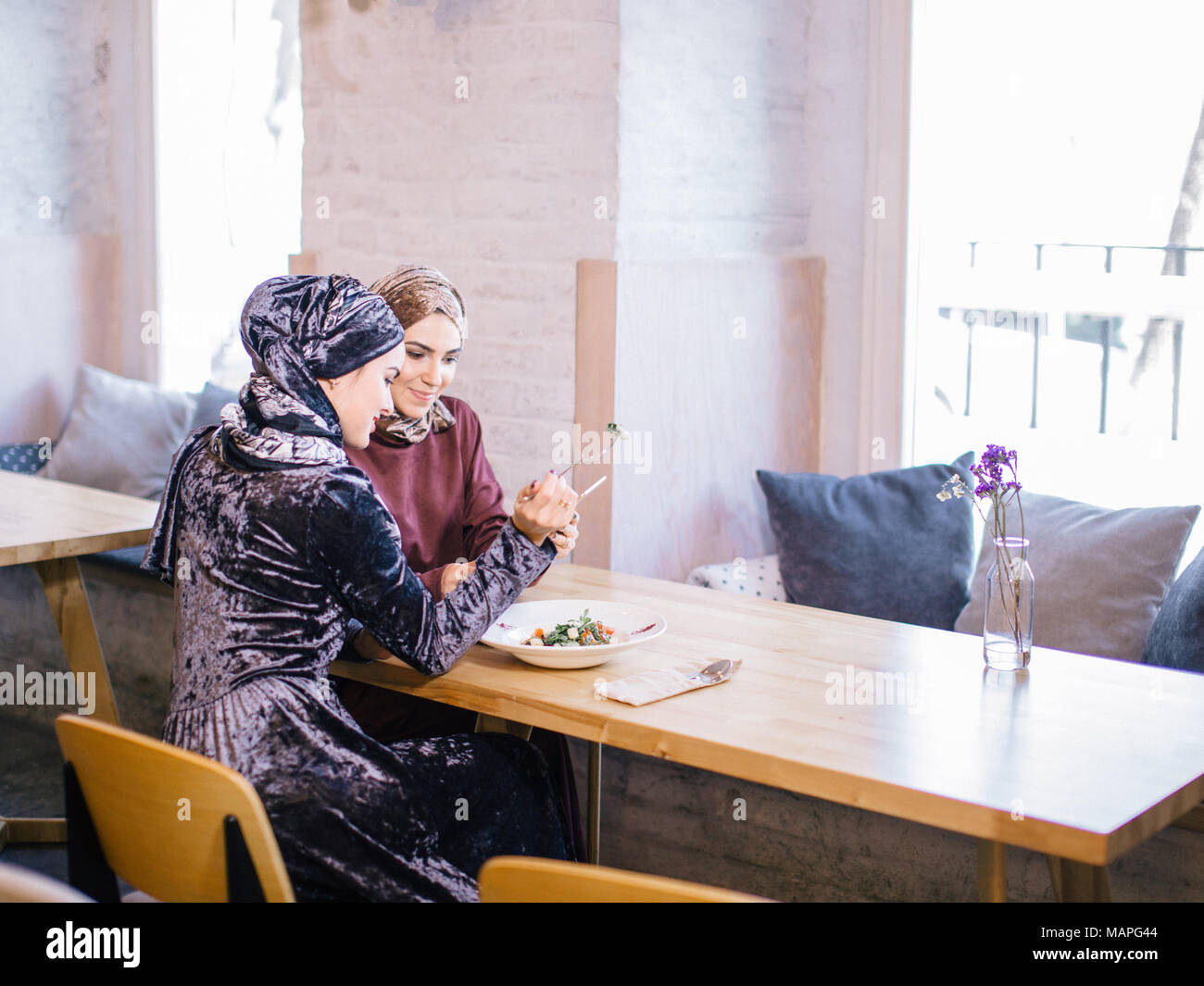 Two Muslim women in cafe, shop online using electronic tablet Stock ...
