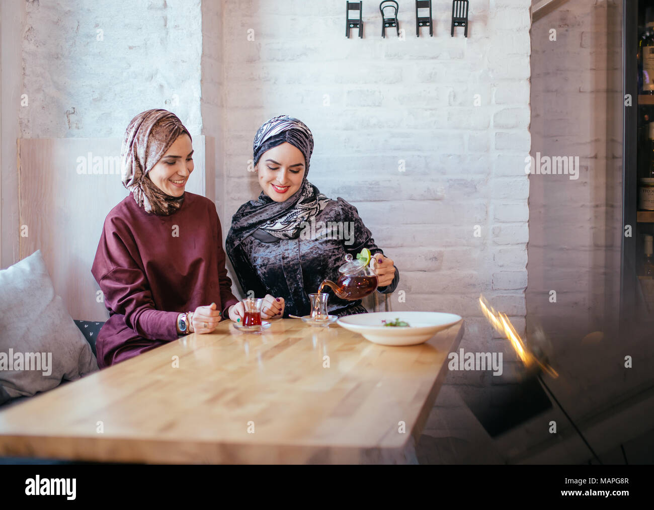 two caucasian muslim woman drinking tea in cafe Stock Photo - Alamy