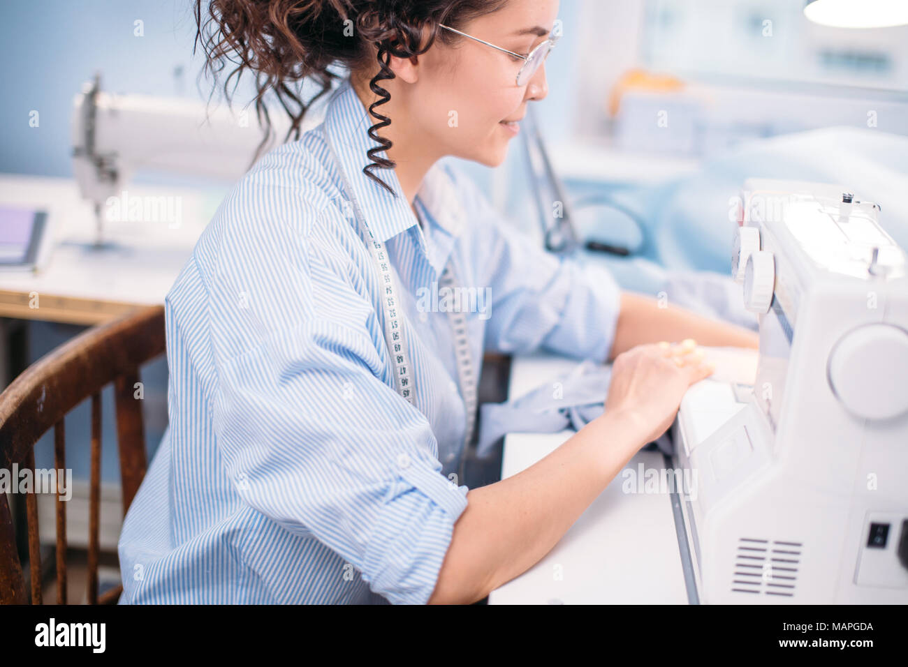cropped photo of tailor making clothers on sewing machine at design ...