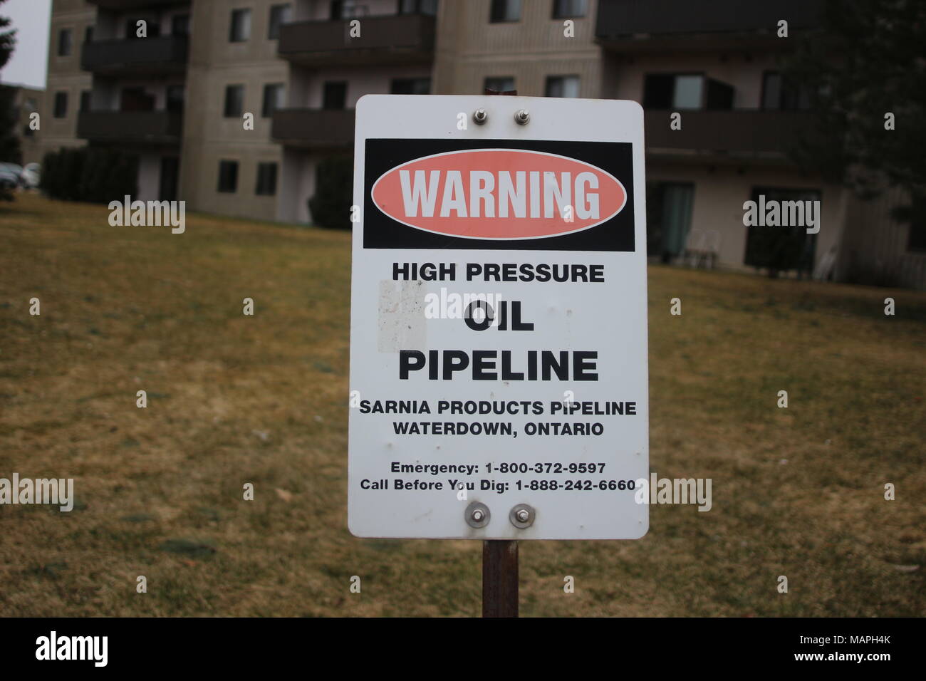 Petroleum pipeline warning sign in green grassy meadow Stock Photo - Alamy