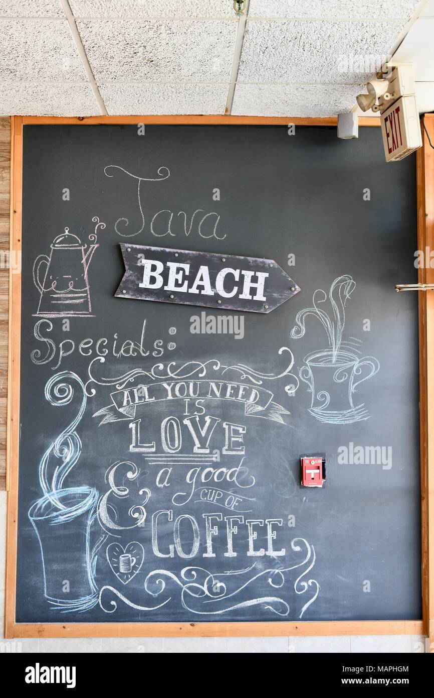 Chalkboard inside small coffee shop that says all you need is love and ...