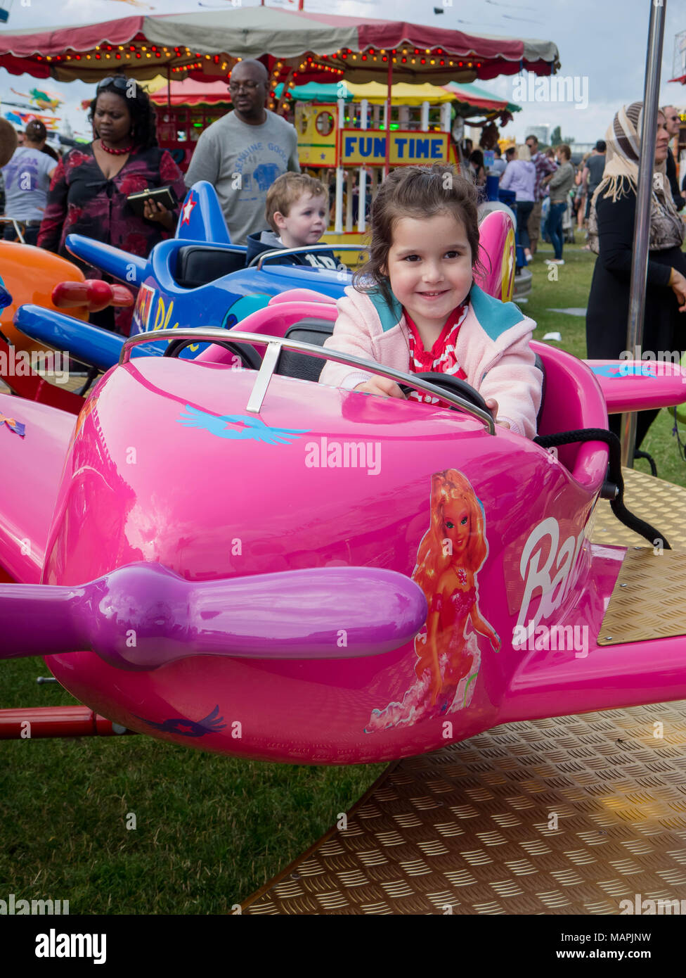 A young child rides on a fairground merry go round Stock Photo - Alamy