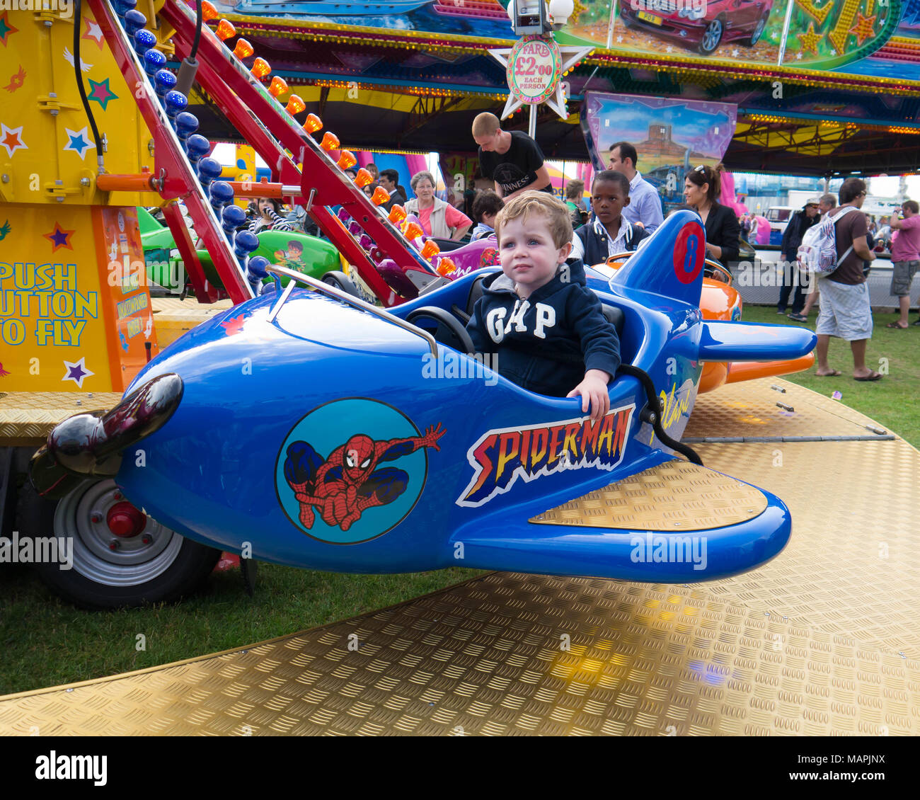A young child rides on a fairground merry go round Stock Photo - Alamy