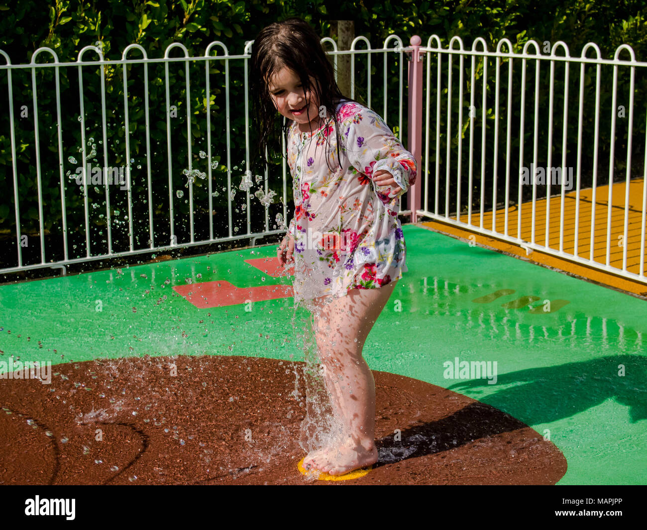 A young girl plays in a splash park on a summers day Stock Photo - Alamy