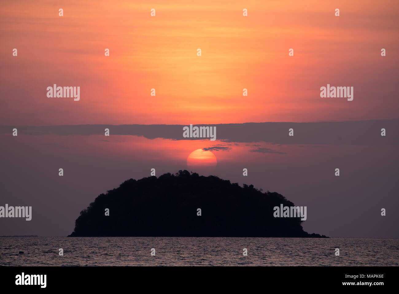 Sunrise behind island colorful on sky background Stock Photo - Alamy