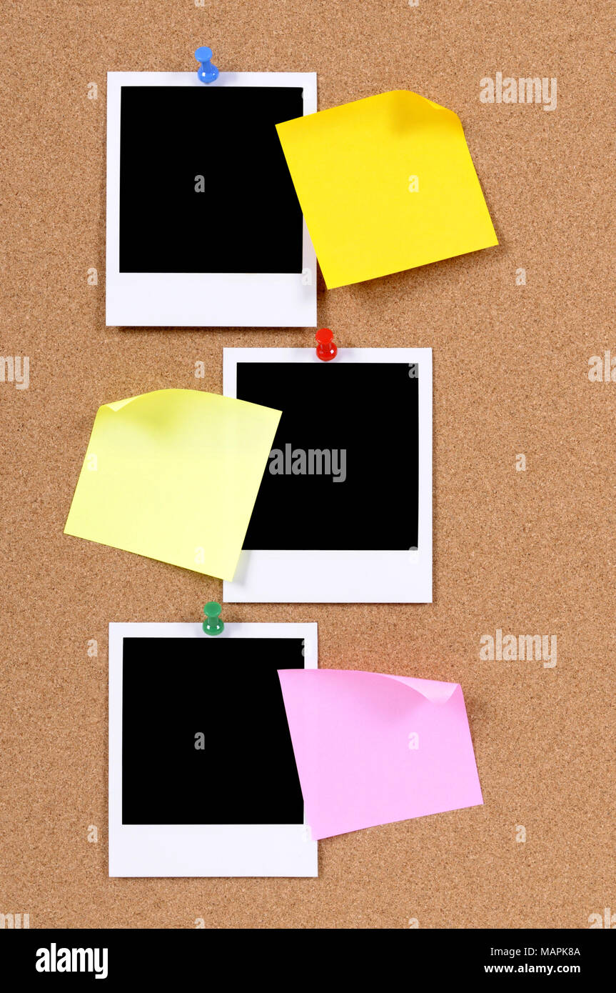 Blank photo prints with sticky notes pinned to a cork bulletin board ...