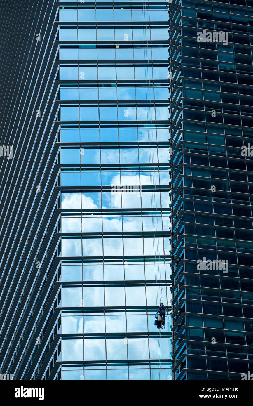 group of workers cleaning windows service on high rise building, wide ...