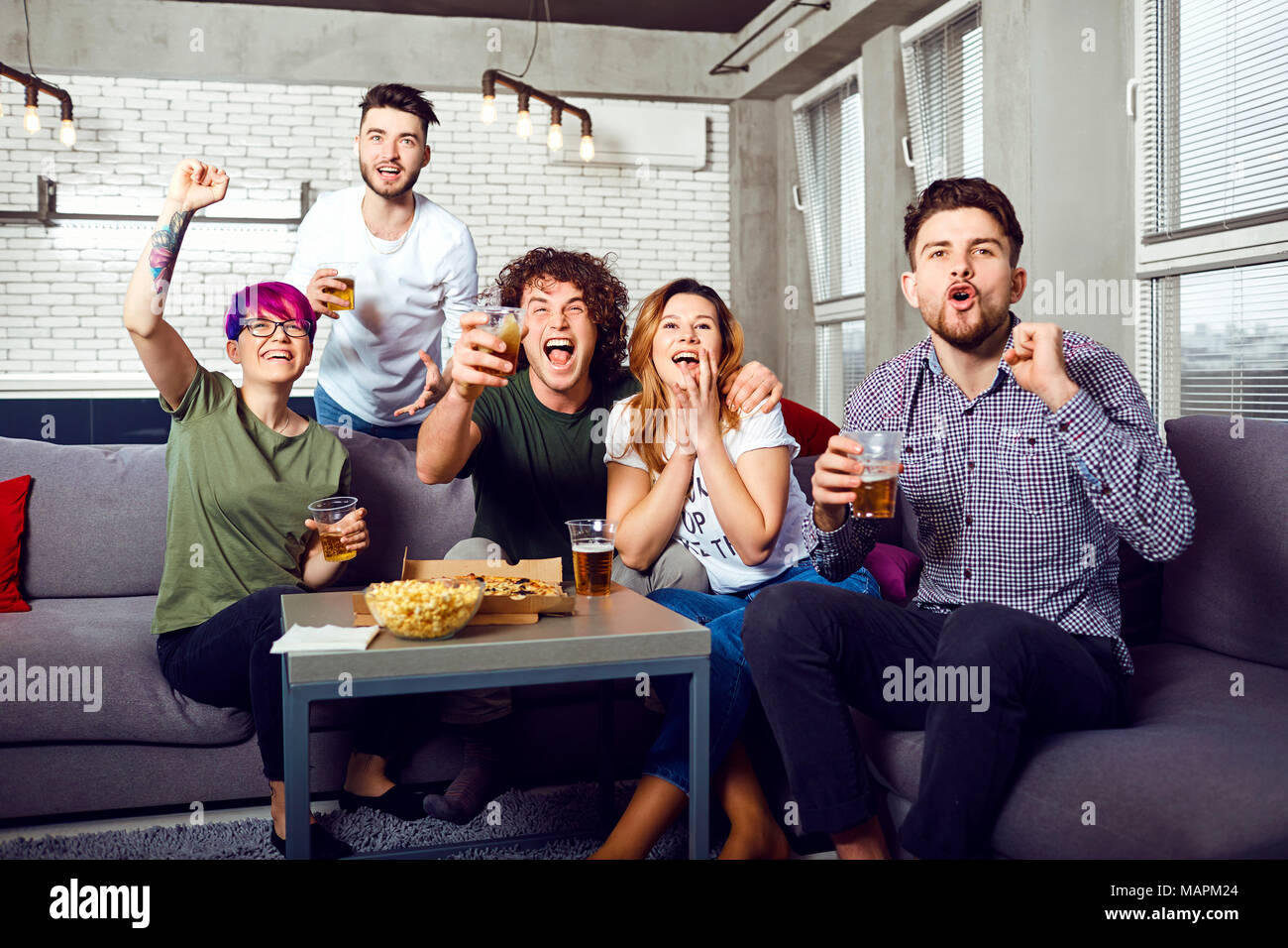 A group of friends are having fun watching TV in the room Stock Photo ...