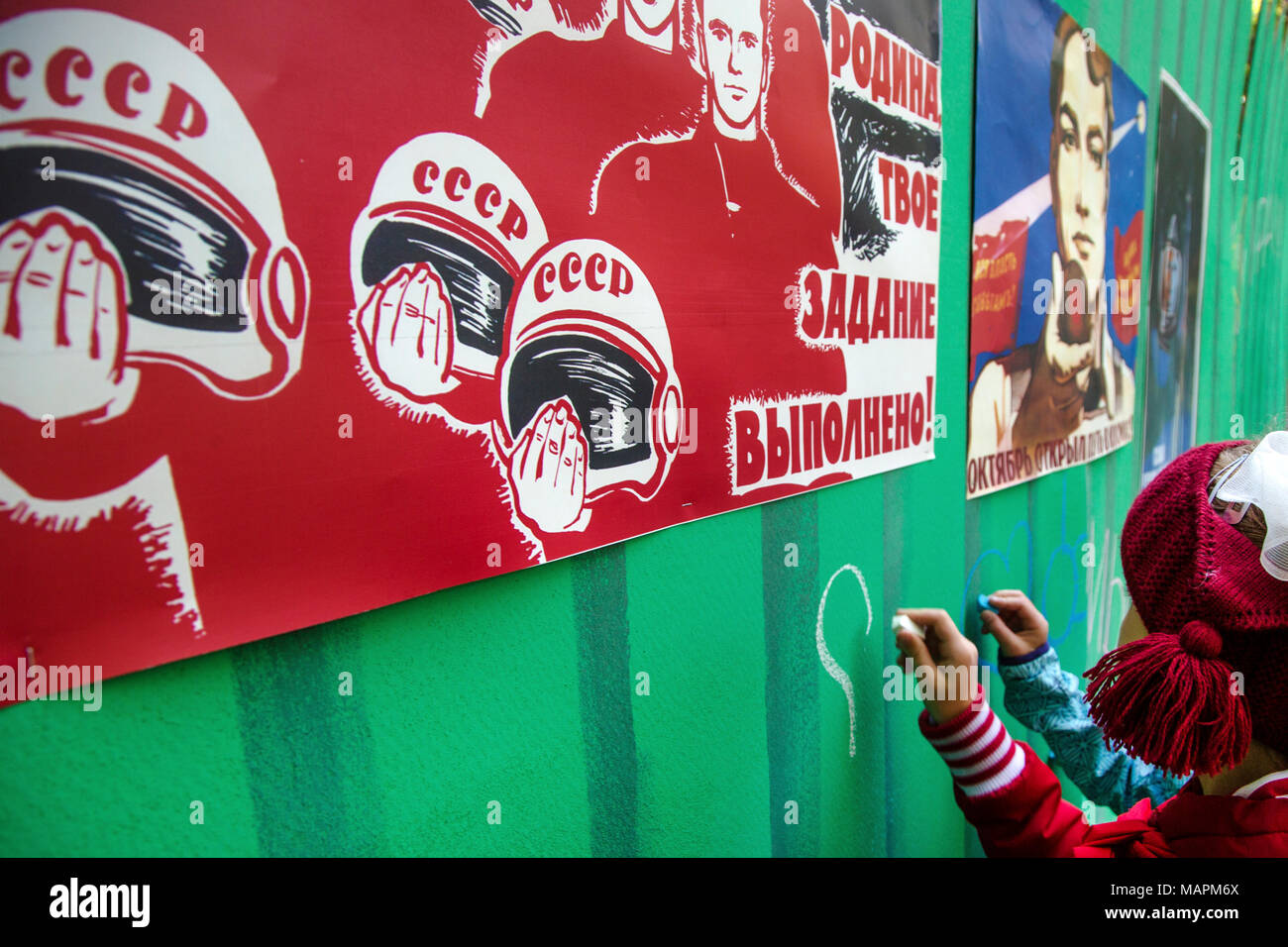 girls in school uniform write on the wall with chalk with posters ...