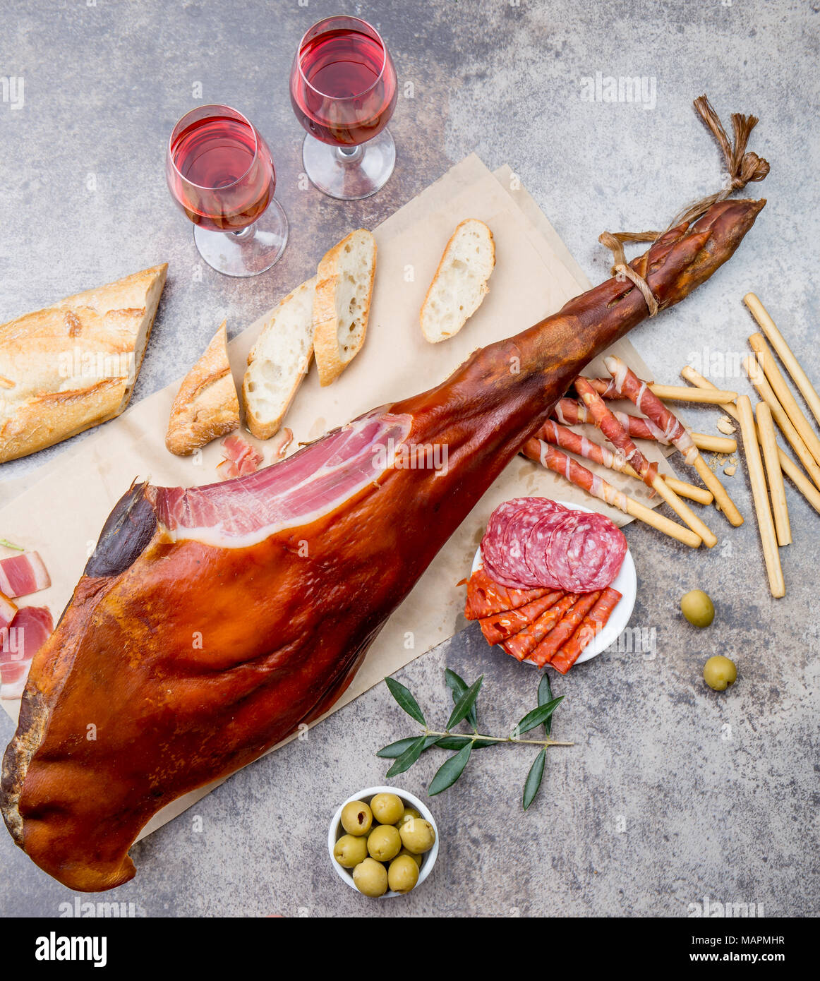 Whole leg HAM JAMON SERRANO and rose wine on gray background. Top view ...