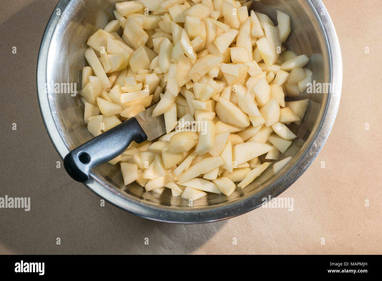 Chopped peeled pears and a knife in a metal bowl Stock Photo - Alamy