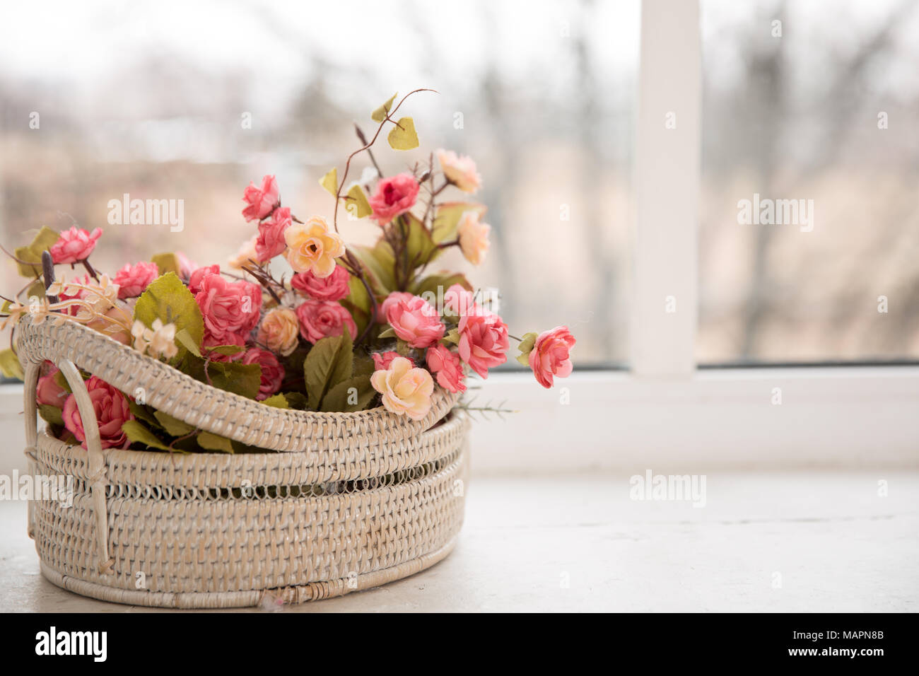 colorful roses and flowers in a basket on window-sill Stock Photo - Alamy