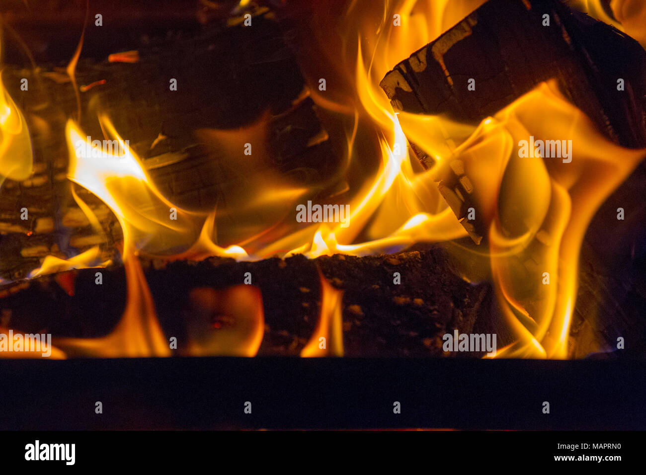 Logs burning in a log fire Stock Photo - Alamy